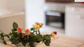Uma mesa de jantar com um vaso de flores contendo rosas.
