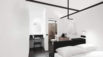 Quarto de hotel moderno com cama, mesa de cabeceira e escrivaninha com cadeira. É visível uma área de chuveiro ao fundo.