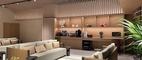 Uma área de estar moderna com sofá, canto de café e uma planta grande.