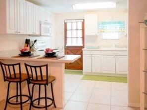 Um frigorífico, um micro-ondas, um forno, uma placa de cozinha 