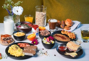 Uma mesa de café da manhã com diversos pratos e bebidas.