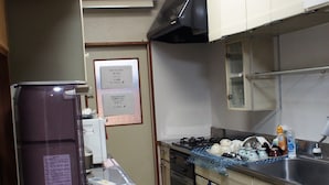 Uma cozinha compacta com geladeira, fogão, pia e armários.