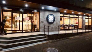 Entrada de hotel com uma placa indicando "88 HOTEL SHIMSAISHI".
