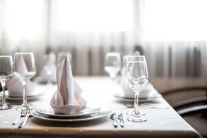 Uma mesa de jantar bem posta, com pratos, copos e talheres.