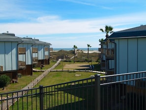 Uma propriedade à beira-mar com várias cabanas no estilo de bangalô, um deck de madeira e vista desobstruída para o oceano.