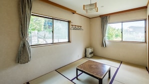 Um quarto japonês tradicional, com piso de tatame, uma mesa baixa e portas deslizantes.
