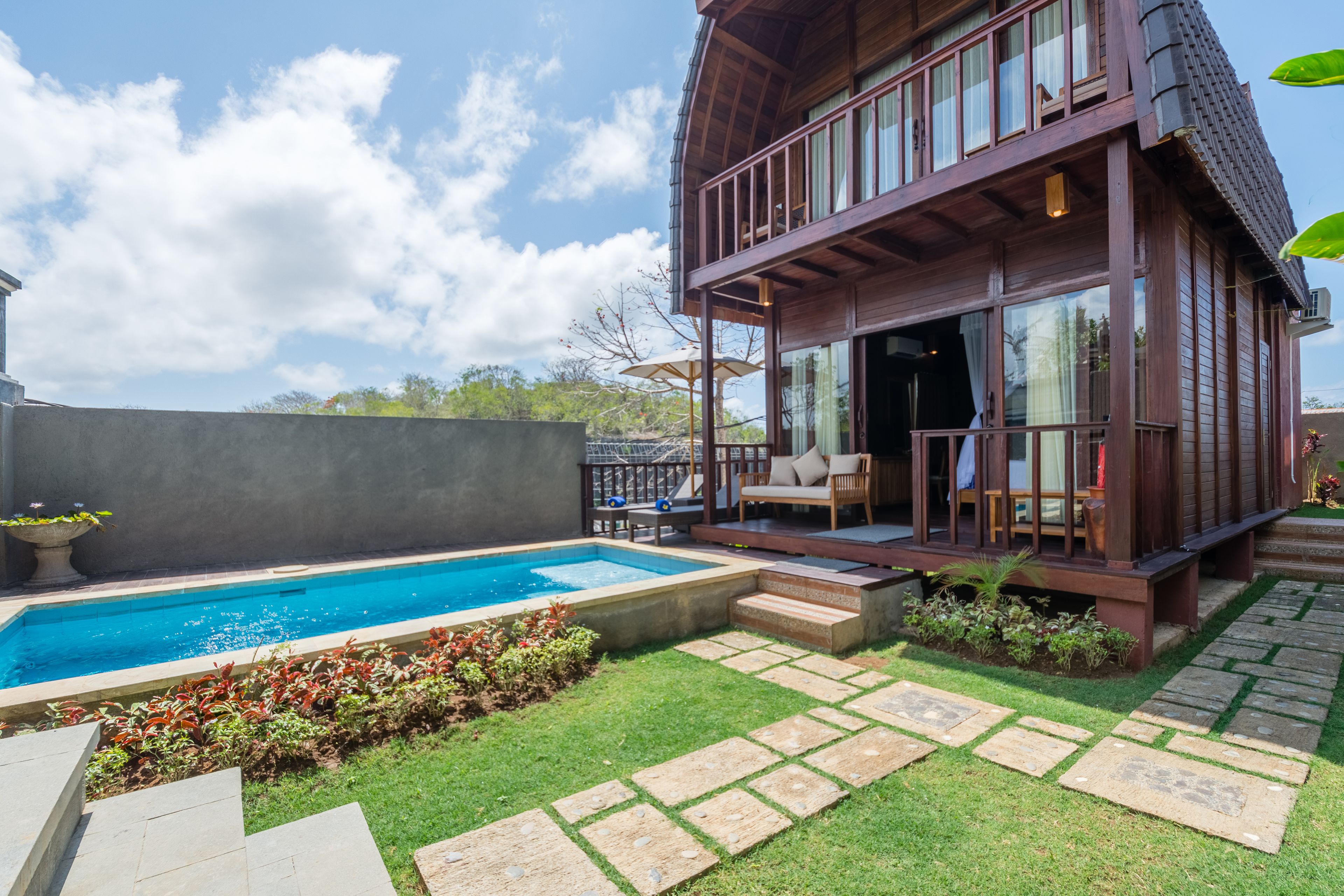Uma casa moderna de dois andares com piscina, área de estar externa e um jardim bem cuidado.