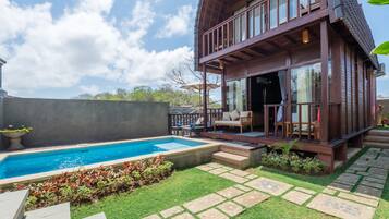 Uma casa moderna de dois andares com piscina, área de estar externa e um jardim bem cuidado.
