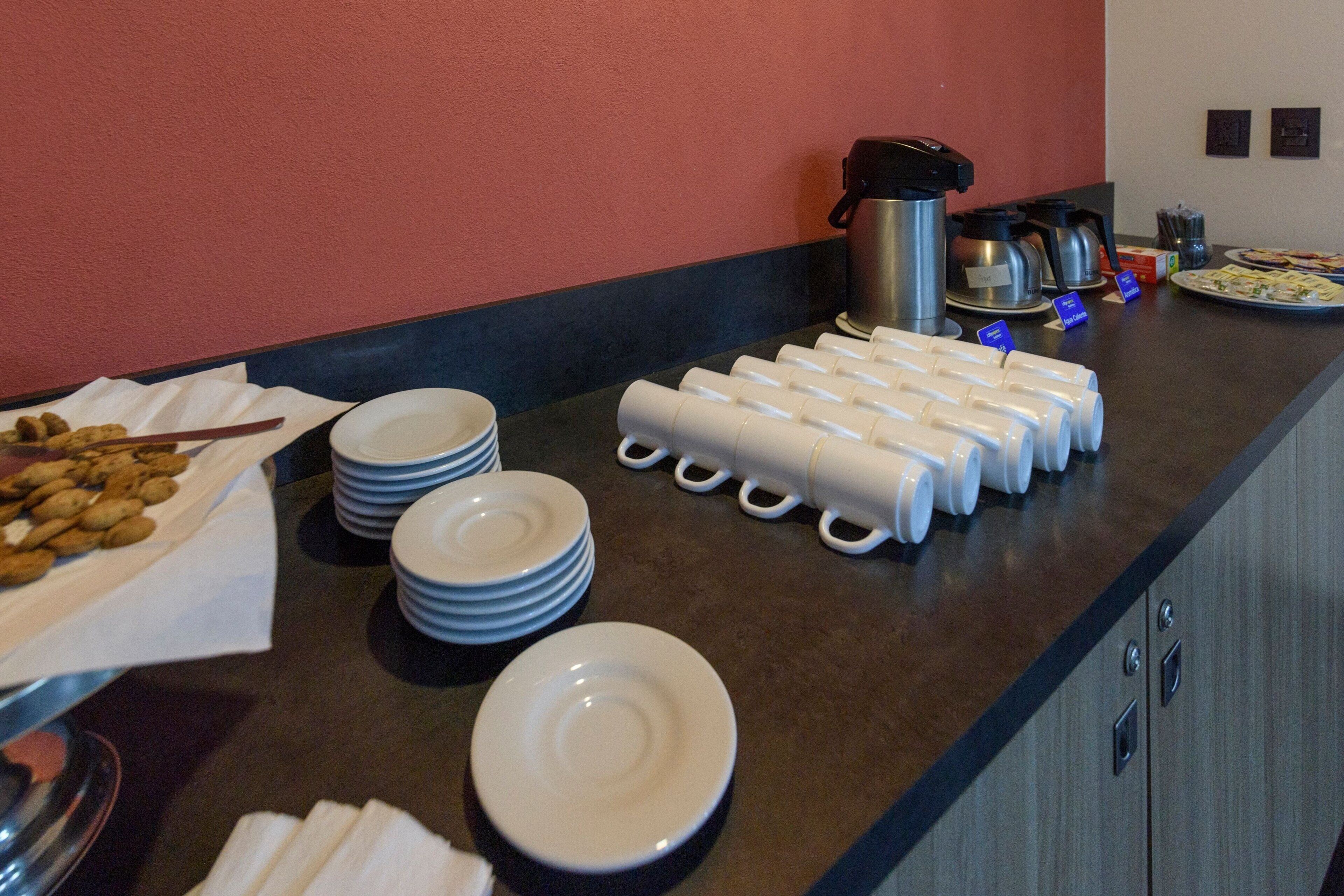 Disposição de buffet com pratos, tigelas e utensílios.