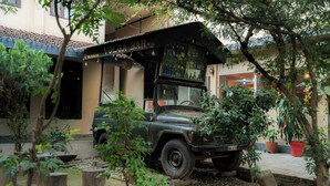 Um jipe militar antigo estacionado em frente a um bar chamado "Volga Bar".