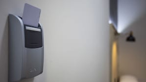 Um leitor de cartão fixado na parede, uma maçaneta e um interruptor de luz.