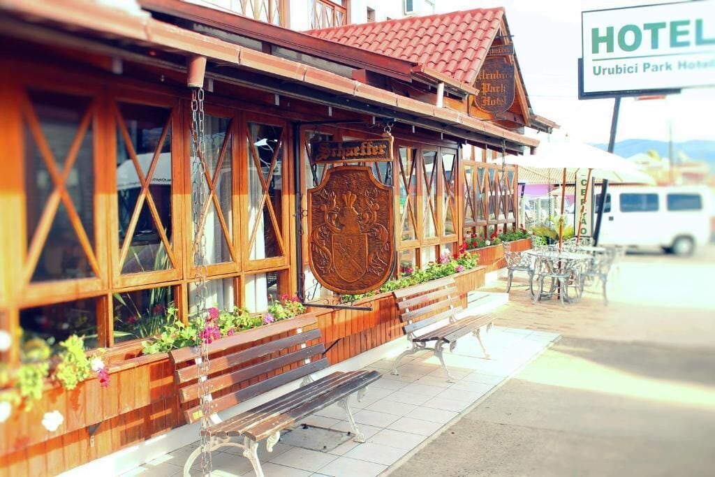 Um edifício de madeira com uma placa que diz 'Hotel Urbici Park Hotel'.