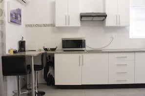 Um frigorífico, um micro-ondas, uma torradeira, utensílios de cozinha 