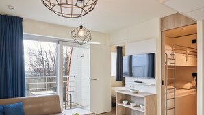 Um apartamento moderno com sofá, mesa de jantar e televisão.