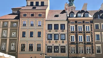 Fileira de edifícios históricos com padrões uniformes nas janelas e um edifício central com decoração elaborada.