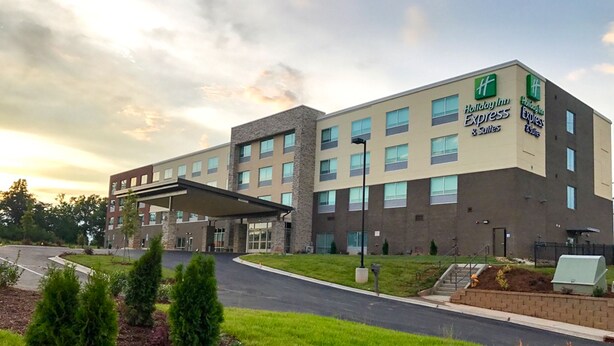 Edifício Holiday Inn Express com entrada coberta, vários andares e estacionamento.