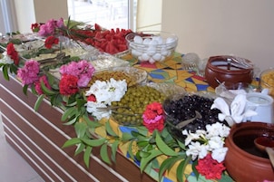 Mesa de buffet com diversos alimentos e flores.