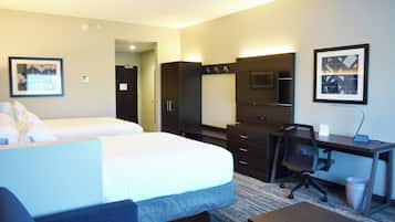 Quarto de hotel com duas camas, uma escrivaninha, uma cadeira, um espelho e uma lixeira.