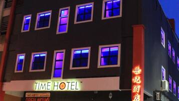 Um hotel com uma placa que diz “TIME HOTEL” e “ABERTO AGORA”.