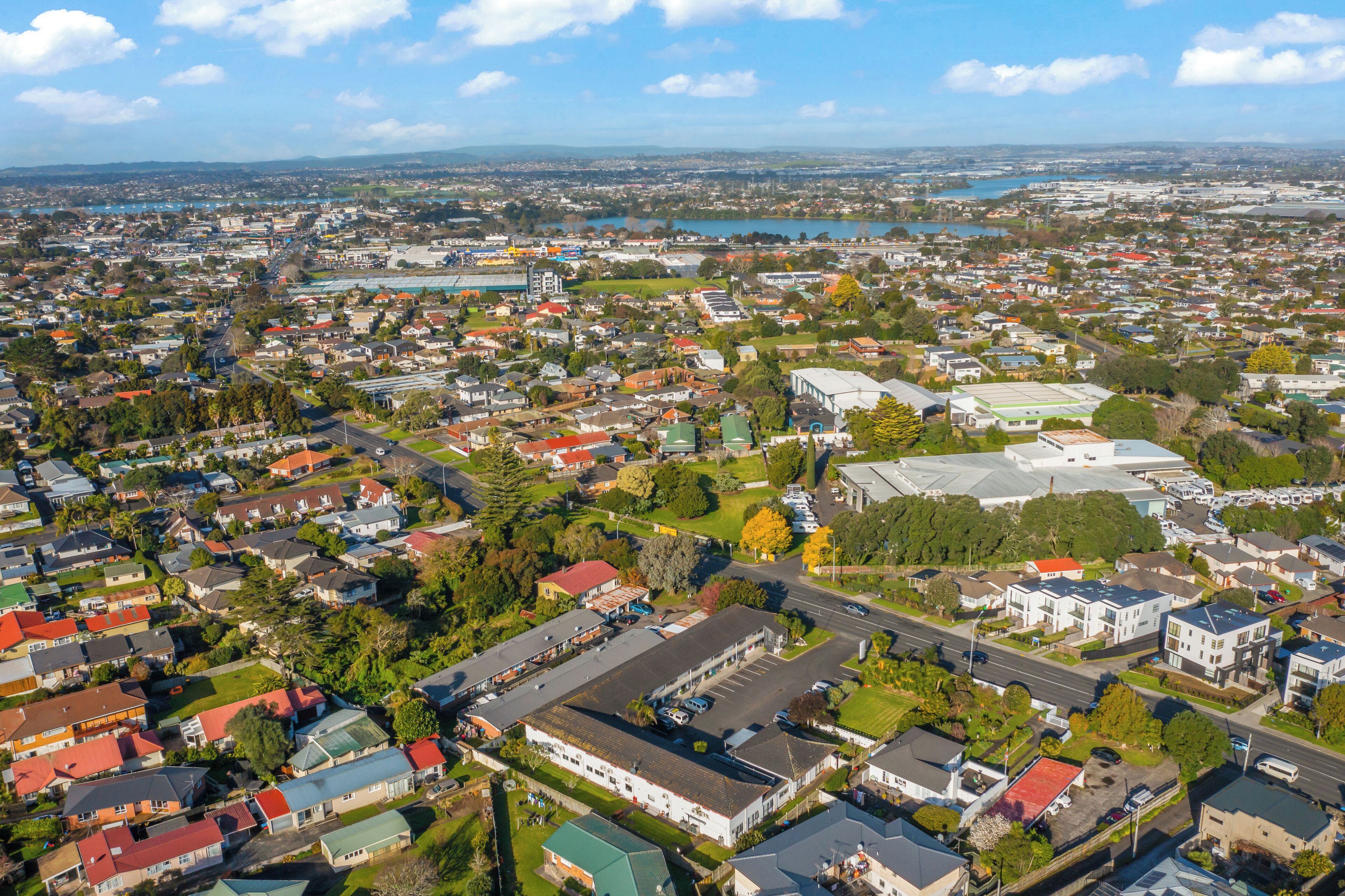 Vista aérea de uma área residencial com casas, ruas e um grande conjunto de edifícios.
