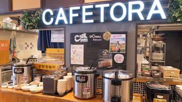Um café com uma placa que diz "CAFETORA" e diversos utensílios de cozinha em exposição.