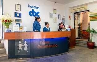 A hotel reception desk with a sign reading "Casa Campesina" and "hoteles dbc".