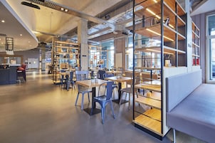 Uma biblioteca moderna com estantes, mesas e cadeiras.