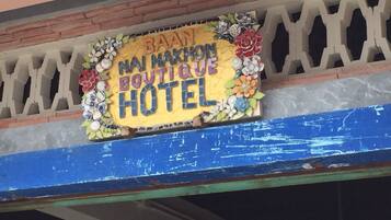 Placa para o Baam Naa Makhon Boutique Hotel, decorada com flores.