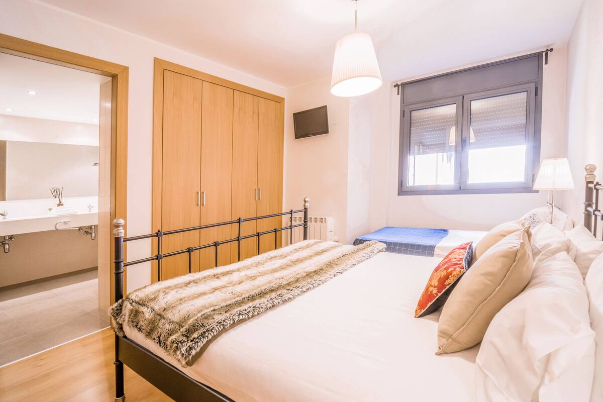 Quarto com cama, janela, guarda-roupa e banheiro.
