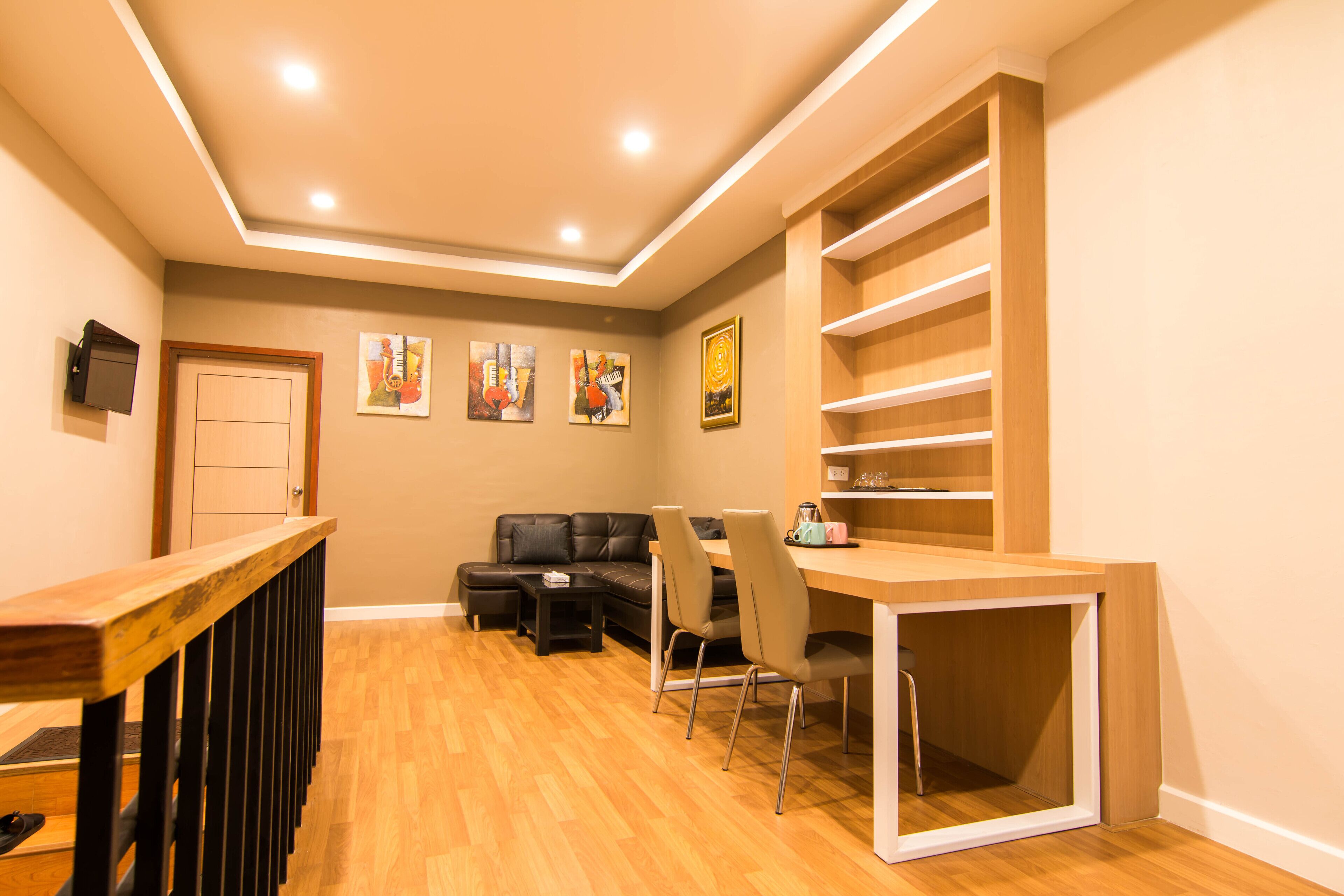 Uma sala de estar moderna com sofá, cadeiras, mesa de centro e escrivaninha de madeira com prateleiras.