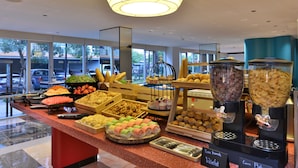 Uma área de buffet com diversos alimentos e um espaço para café.