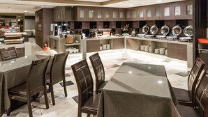 Uma cozinha moderna com ilha central, eletrodomésticos embutidos e um espaço para serviço de buffet.