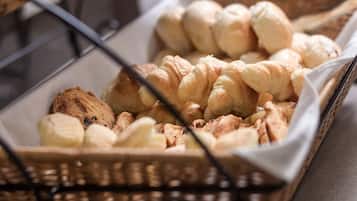 Uma cesta com diversos produtos de panificação, como croissants e muffins.