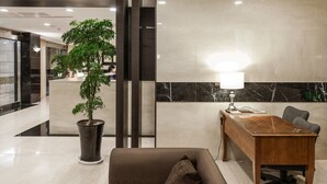 Um hall moderno com uma mesa de madeira, um sofá marrom e uma planta em vaso.