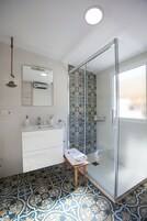 Quarto quádruplo luxo | Banheiro | Chuveiro, secador de cabelo, toalhas de banho, sabonete