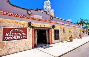 Um edifício com uma placa que diz "Hacienda Morelos" e um campanário.