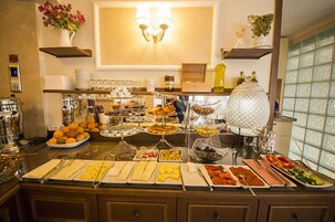 Buffet com diversos alimentos e um abajur decorativo.