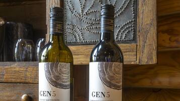 Duas garrafas de Cabernet Sauvignon 2022 GEN5 sobre uma mesa de madeira com um fundo rústico.