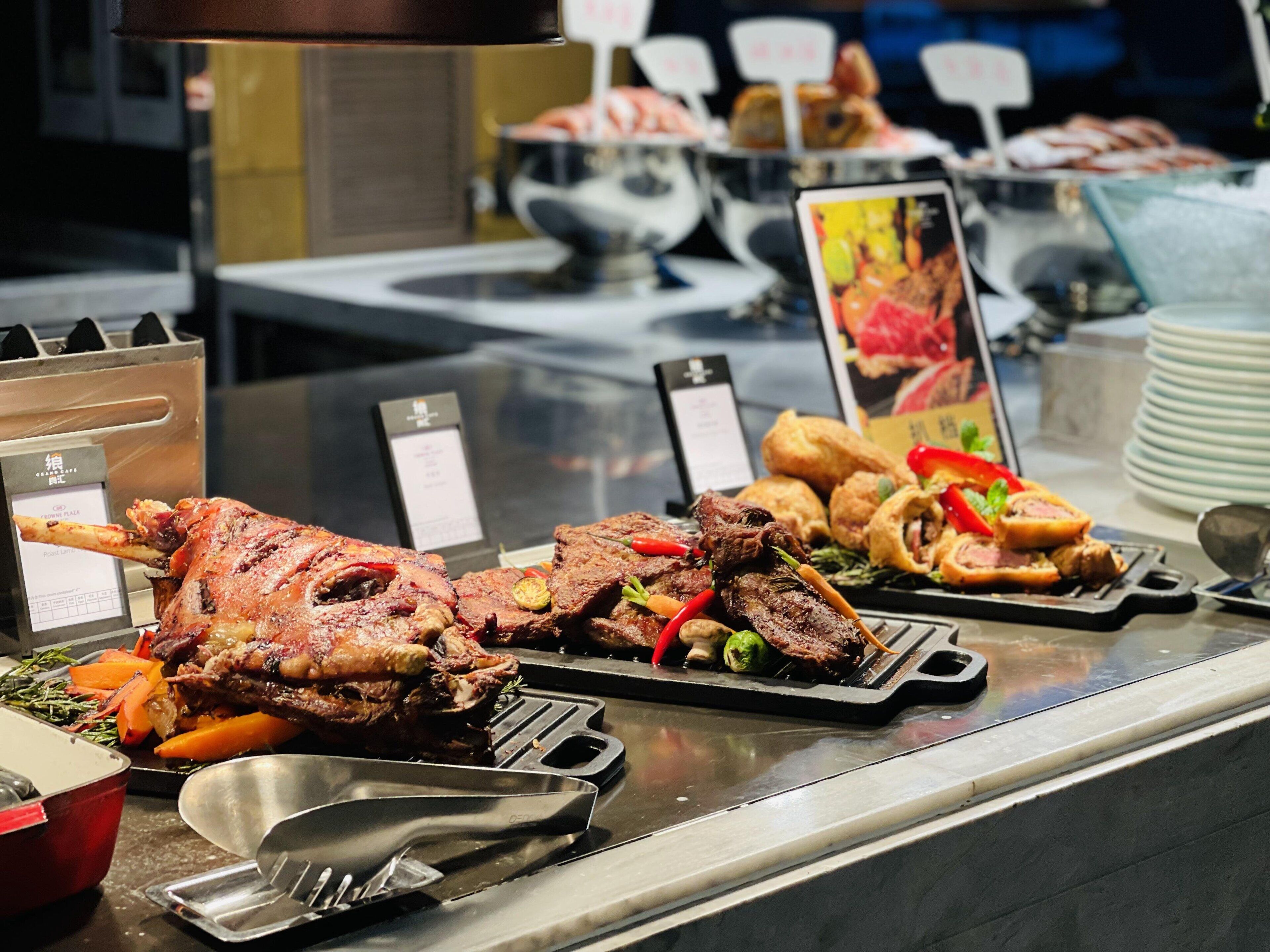 Buffet com diversos pratos, incluindo carne assada e legumes.