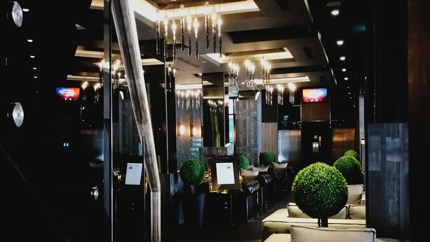 Um interior moderno com escadaria, área de estar e iluminação decorativa.