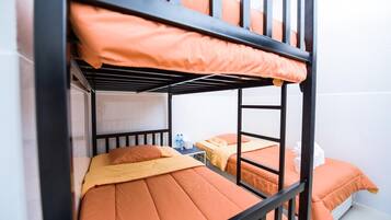 Quarto com beliches, roupa de cama laranja e estrutura de metal preta.