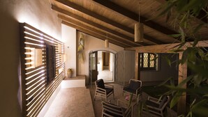 Interior de madeira com área de estar, escada e vista para um jardim.