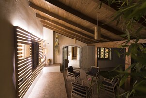 Interior de madeira com área de estar, escada e vista para um jardim.
