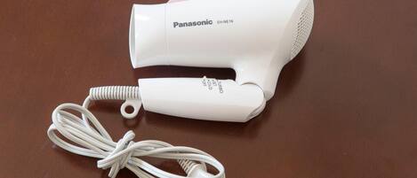 Secador de cabelo Panasonic com um cabo de energia sobre uma superfície castanha.
