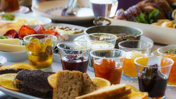 Uma mesa de café da manhã com diversos alimentos e bebidas.