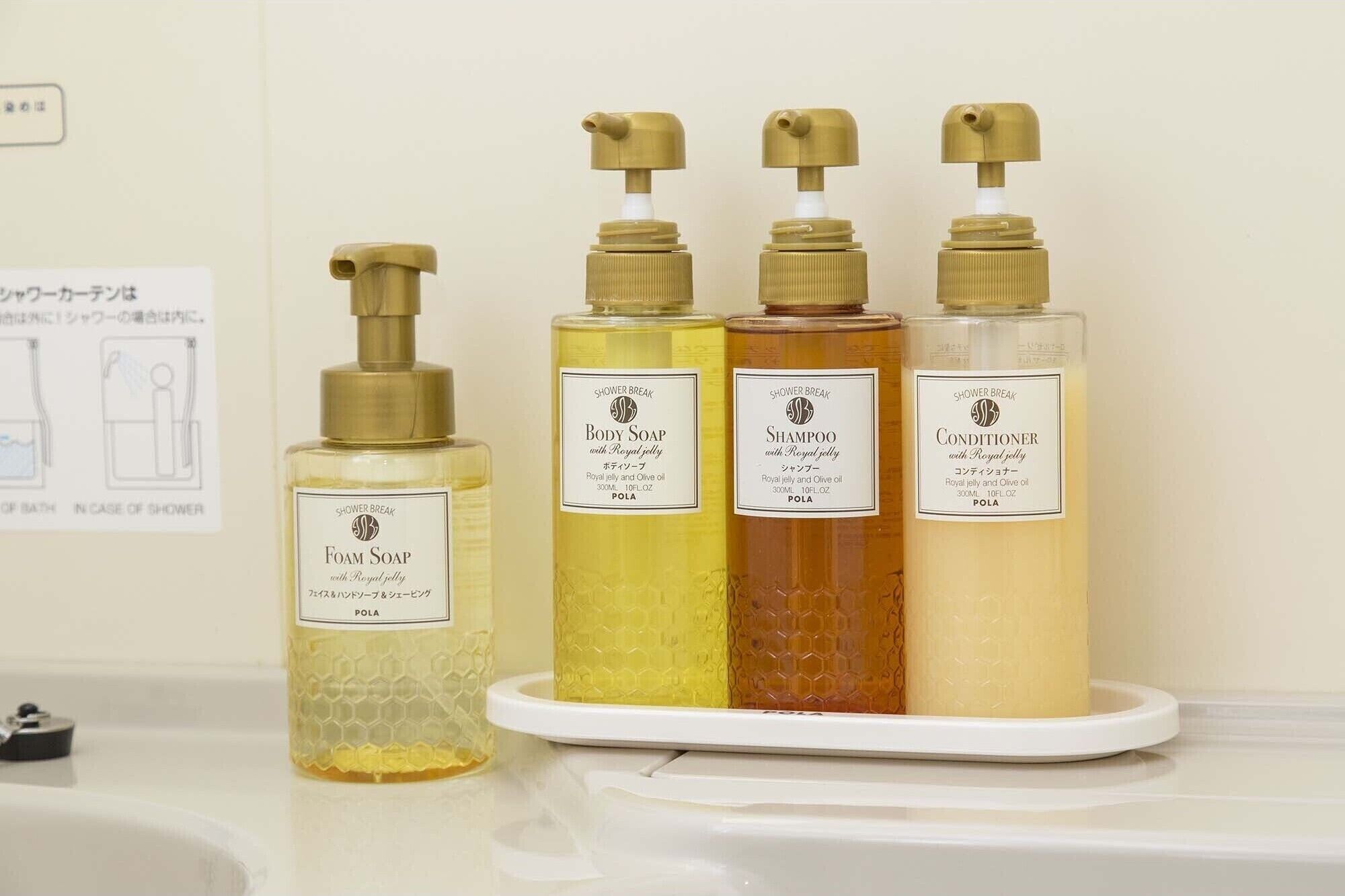 Quatro frascos de produtos Shower Break sobre uma bandeja branca.