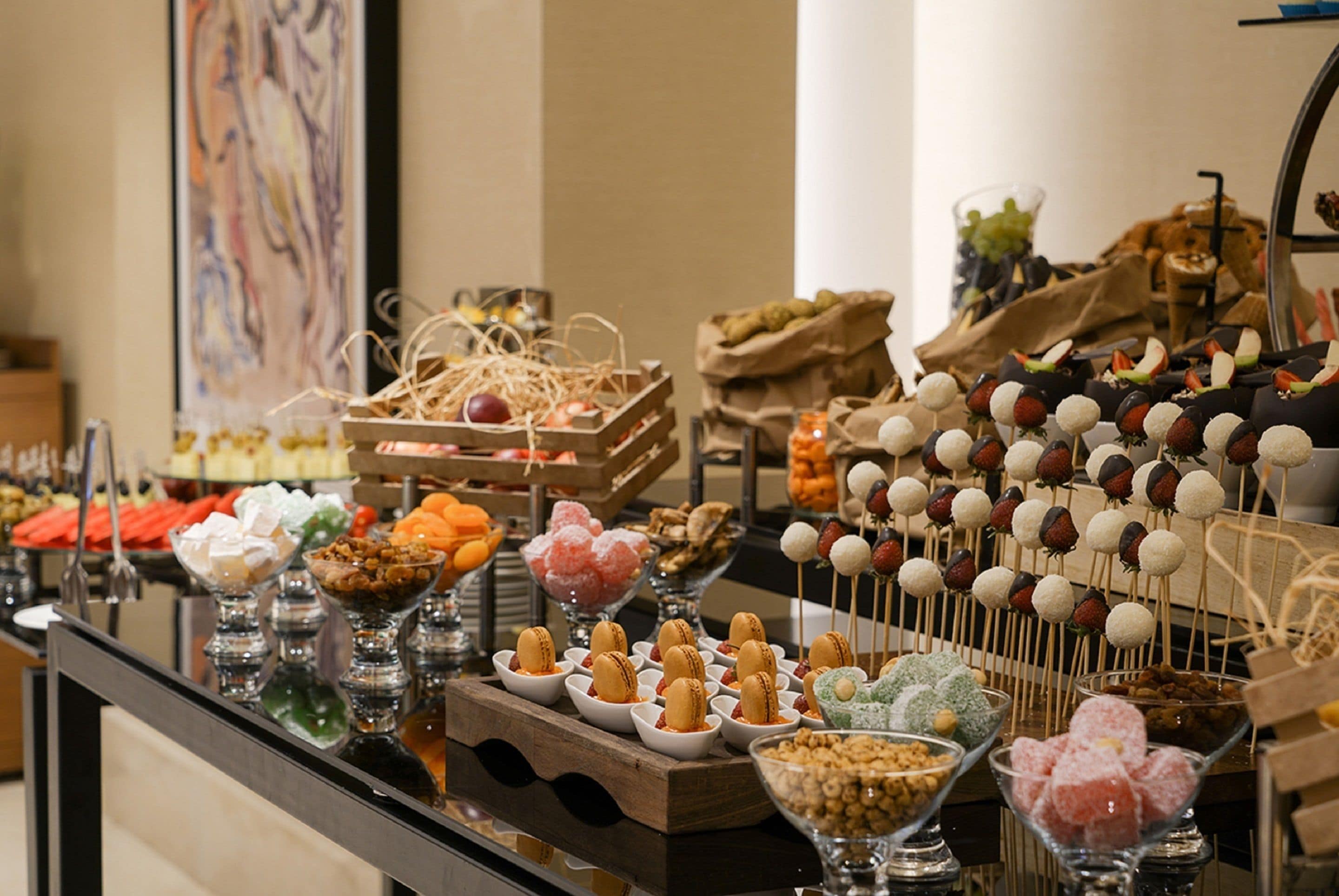 Um buffet com diversos alimentos, incluindo frutas, nozes e sobremesas.