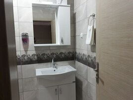 Quarto triplo econômico, suíte | Banheiro | Chuveiro, secador de cabelo, chinelos, toalhas de banho