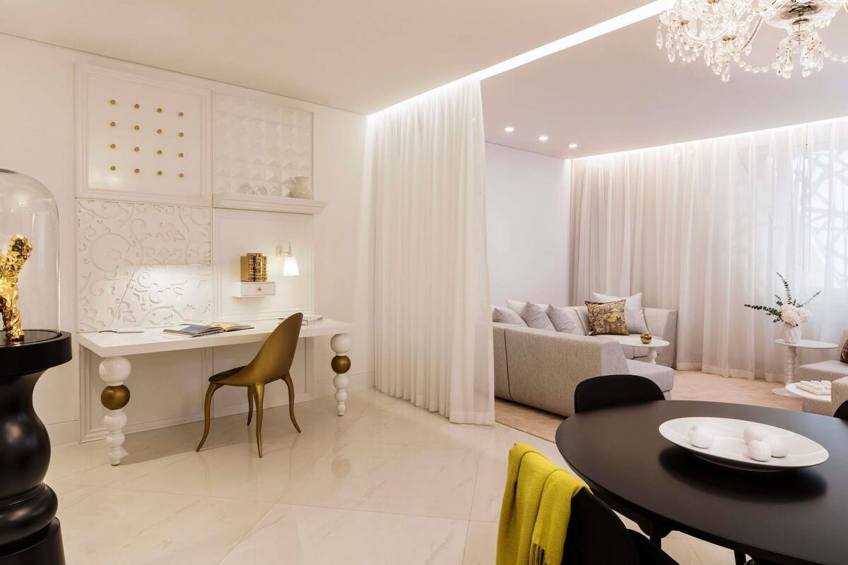 Uma sala de estar moderna com um sofá, uma mesa de jantar com um prato de comida e uma escrivaninha com uma cadeira.
