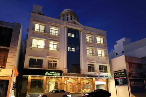 Um edifício de vários andares com uma cúpula central e colunas, com um bar e restaurante no andar térreo.